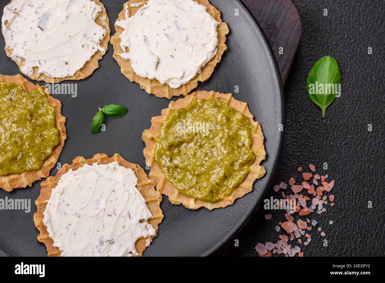 Round snacks with crispy chips or crackers with cream cheese and pesto ...
