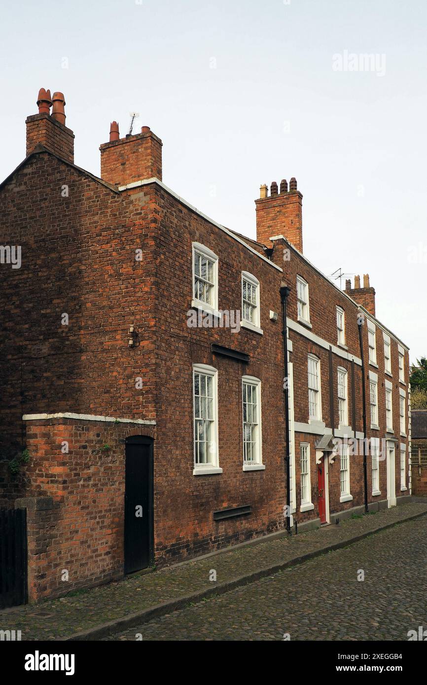 Street of old traditional red brick Georgian houses on a cobbled road ...