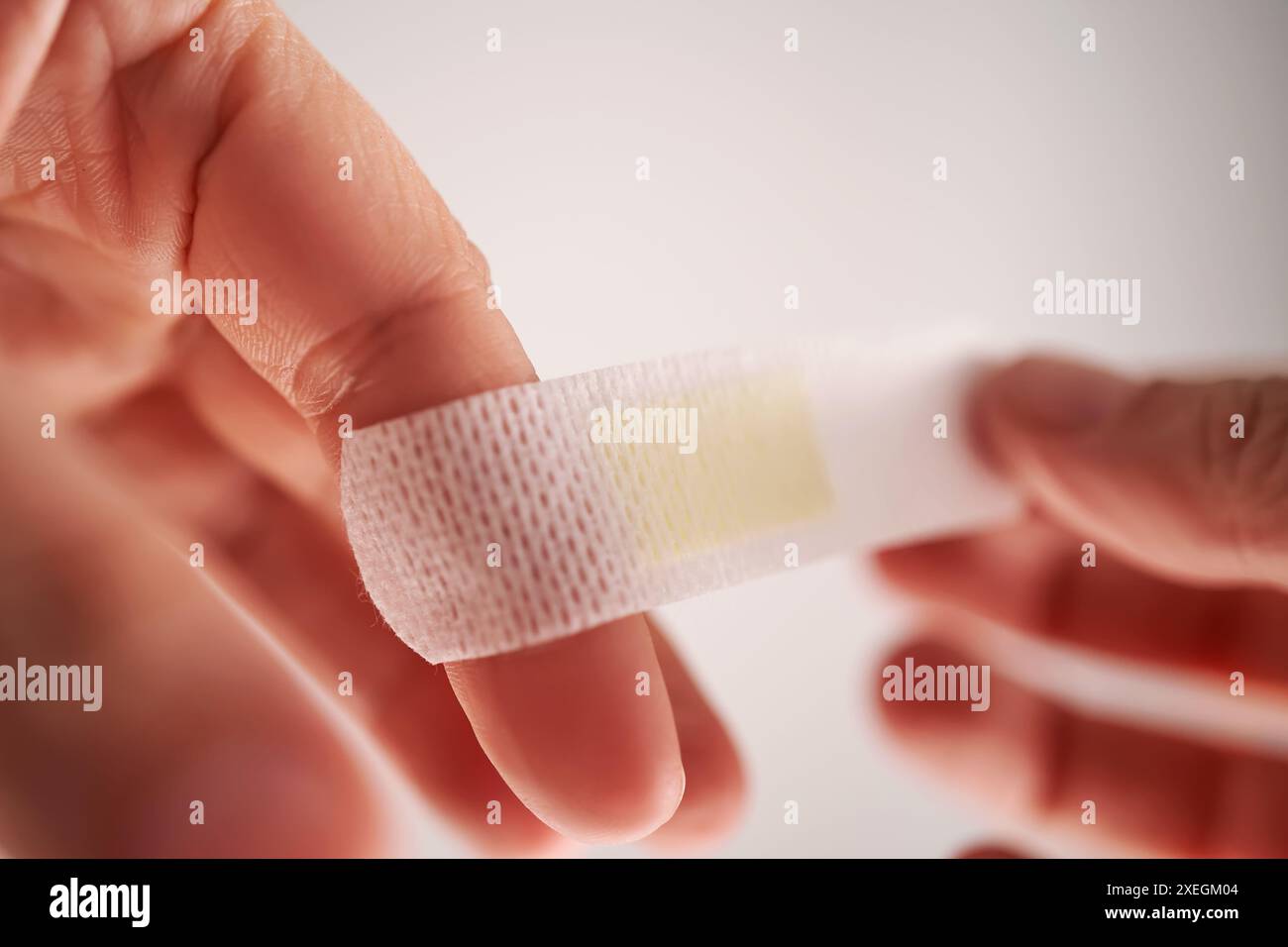 Applying an adhesive plaster to a finger. Close-up Stock Photo - Alamy