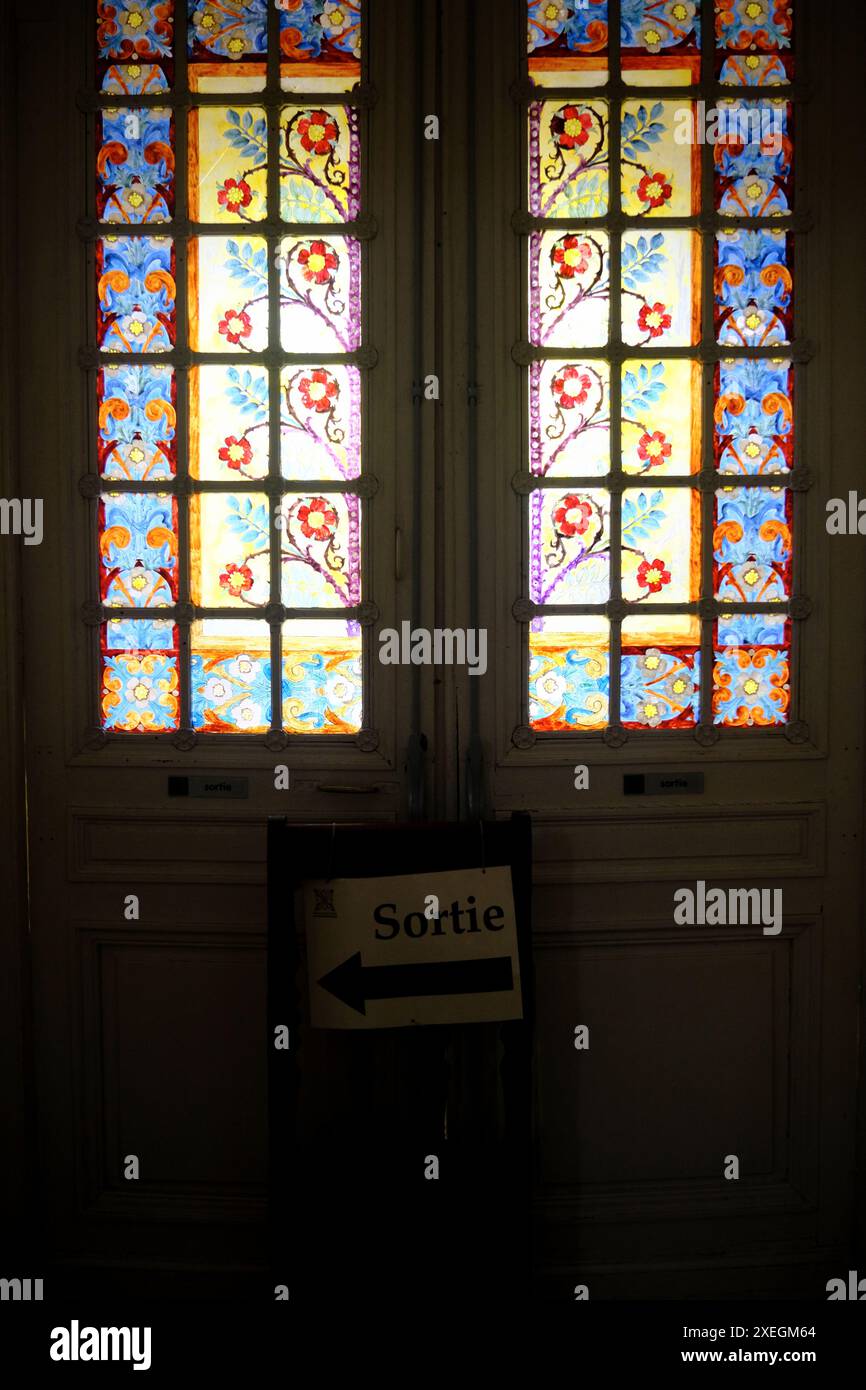 A sorte sign (Exit sign) on a door with stained glass window from the ...