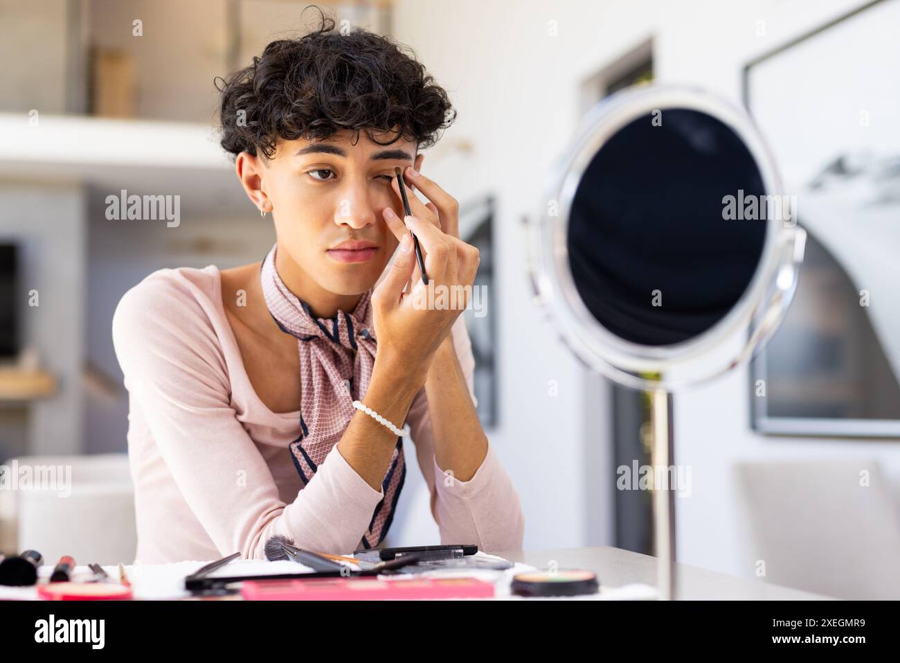 Applying makeup, transgender transgender woman using mirror and ...