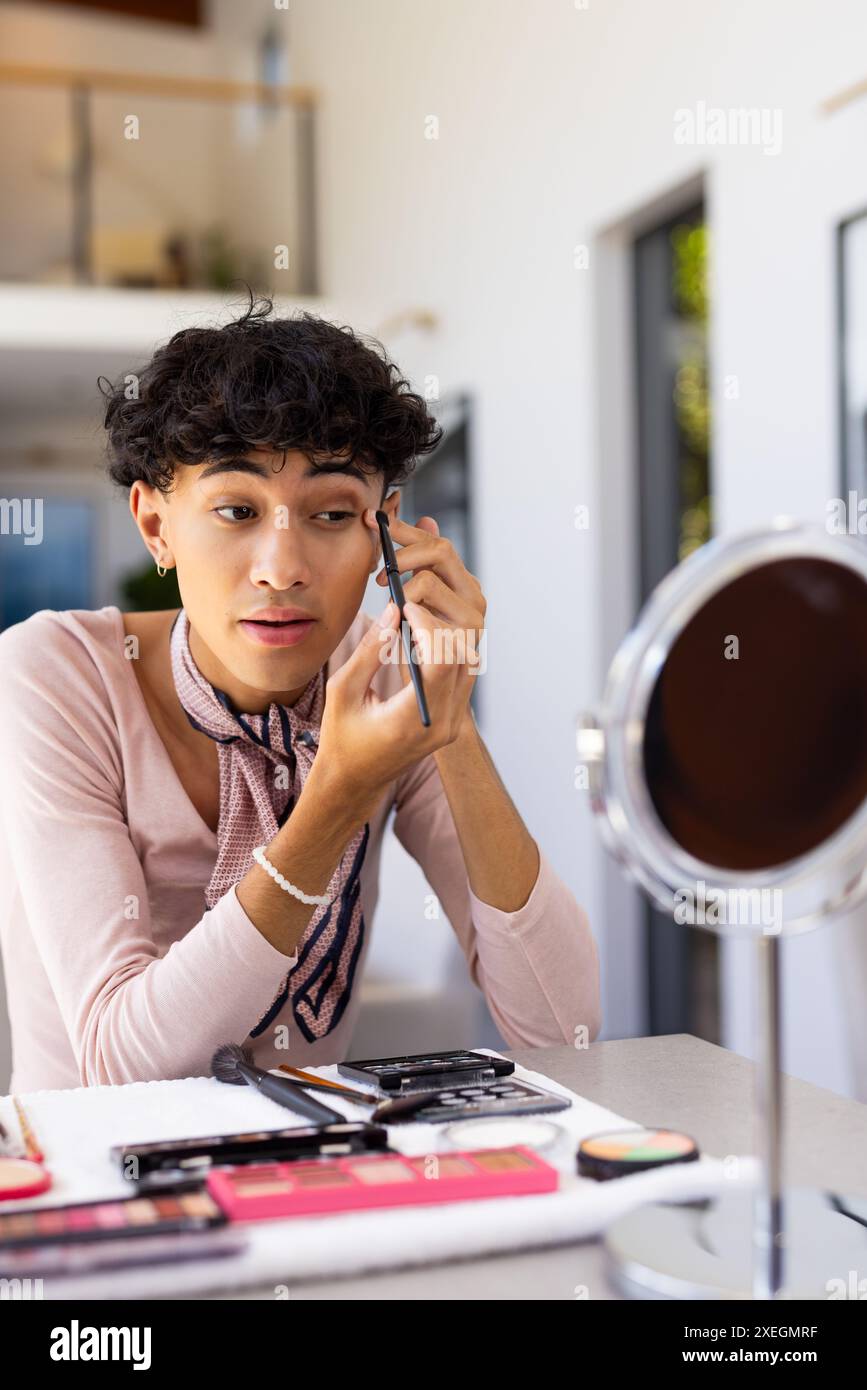 Applying makeup, transgender transgender woman using mirror and brush ...