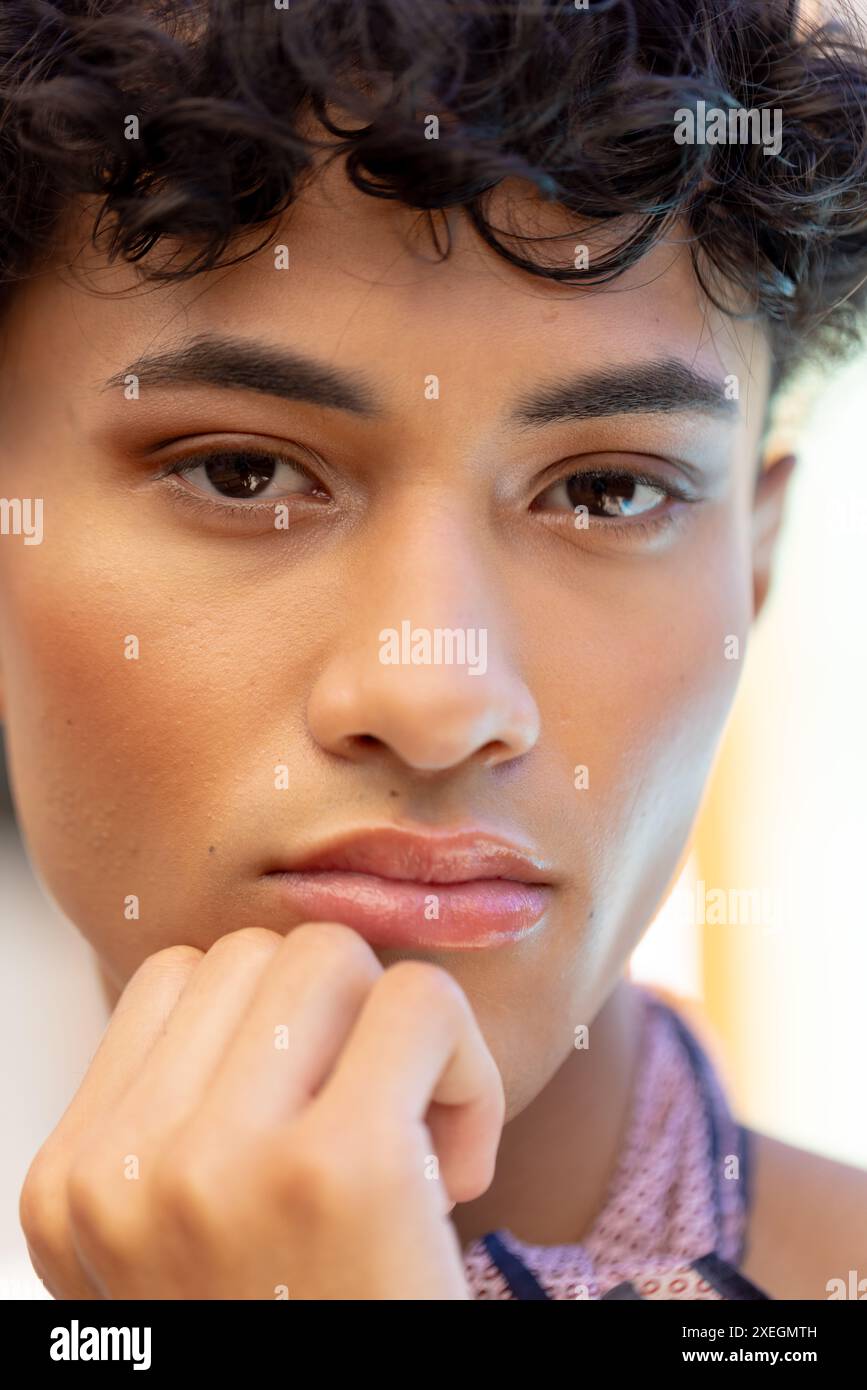 Close-up of transgender transgender woman resting chin on hand, looking ...
