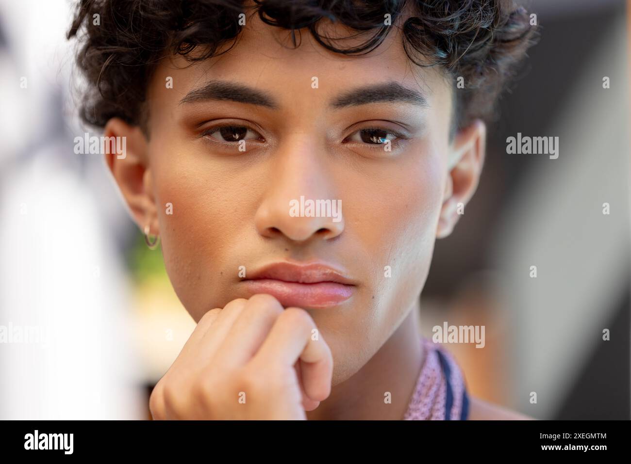 Close-up of thoughtful transgender transgender woman resting chin on ...