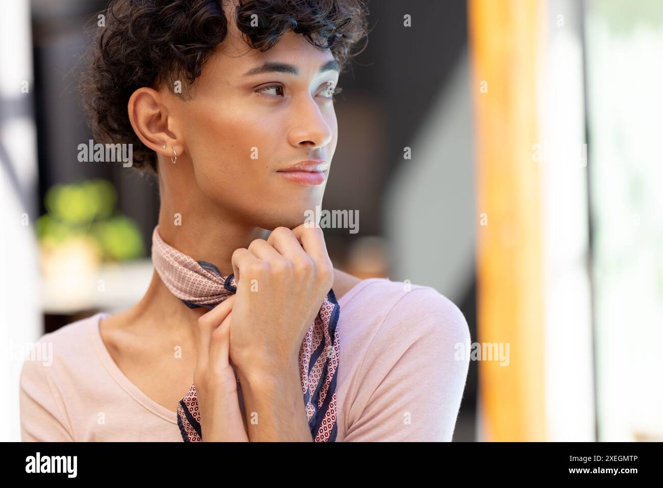 Transgender transgender woman adjusting scarf, looking away, feeling ...