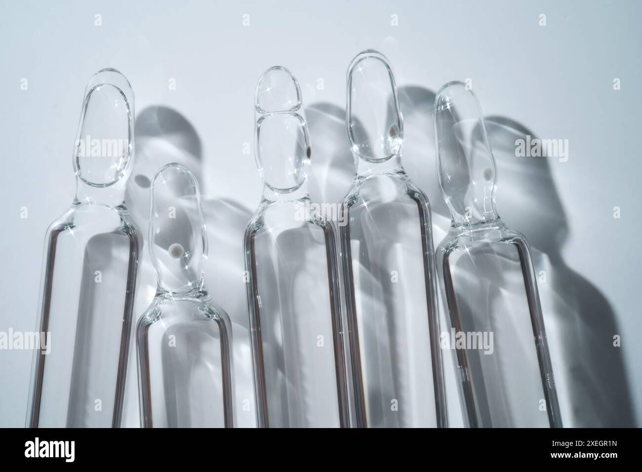 Several ampoules for injection with medicines on a blue background ...