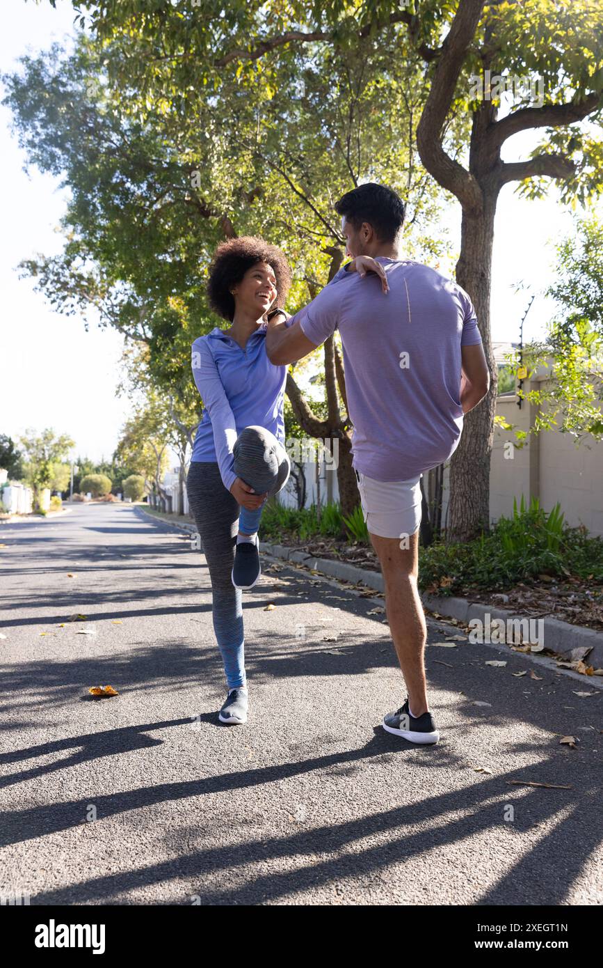 Stretching and warming up, couple exercising together on suburban ...