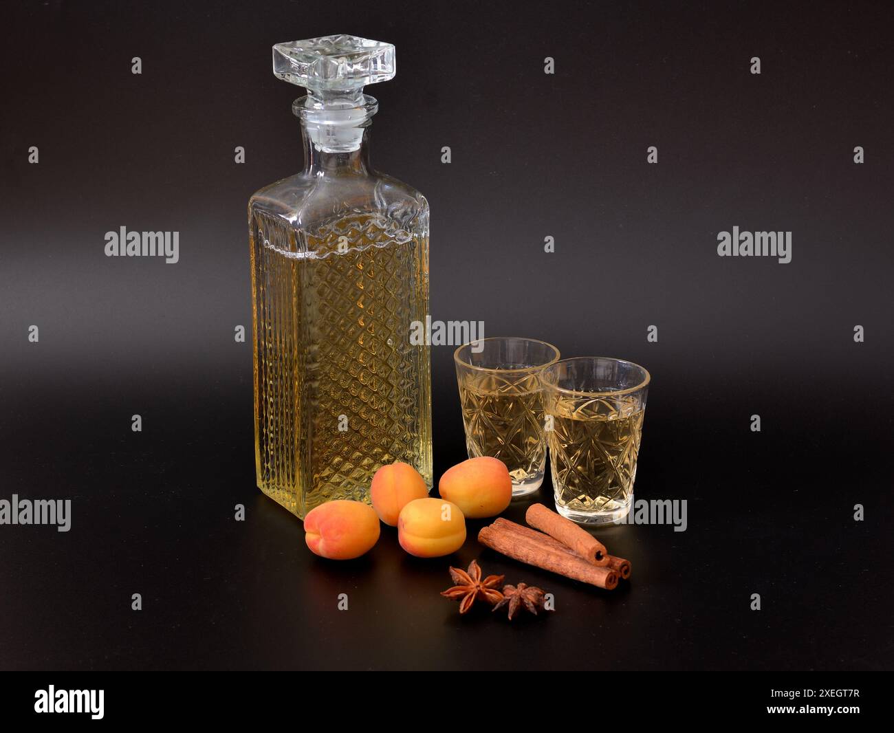 Apricot liqueur with cinnamon and anise on a black background, a ...
