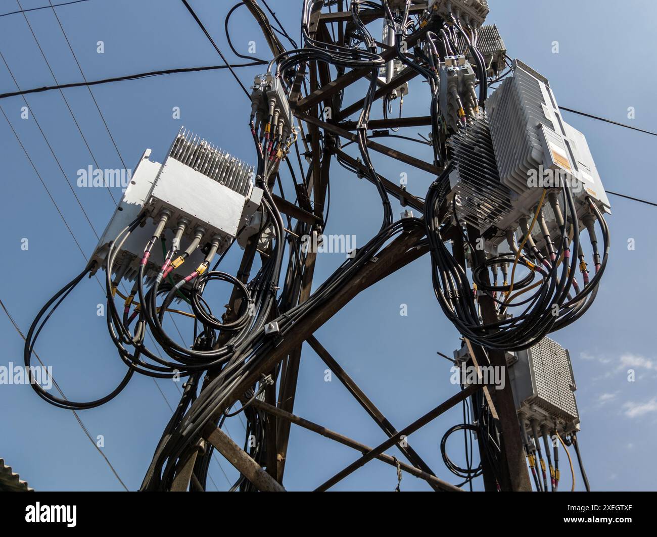 Cluttered utility pole with assortment of electronic equipment ...