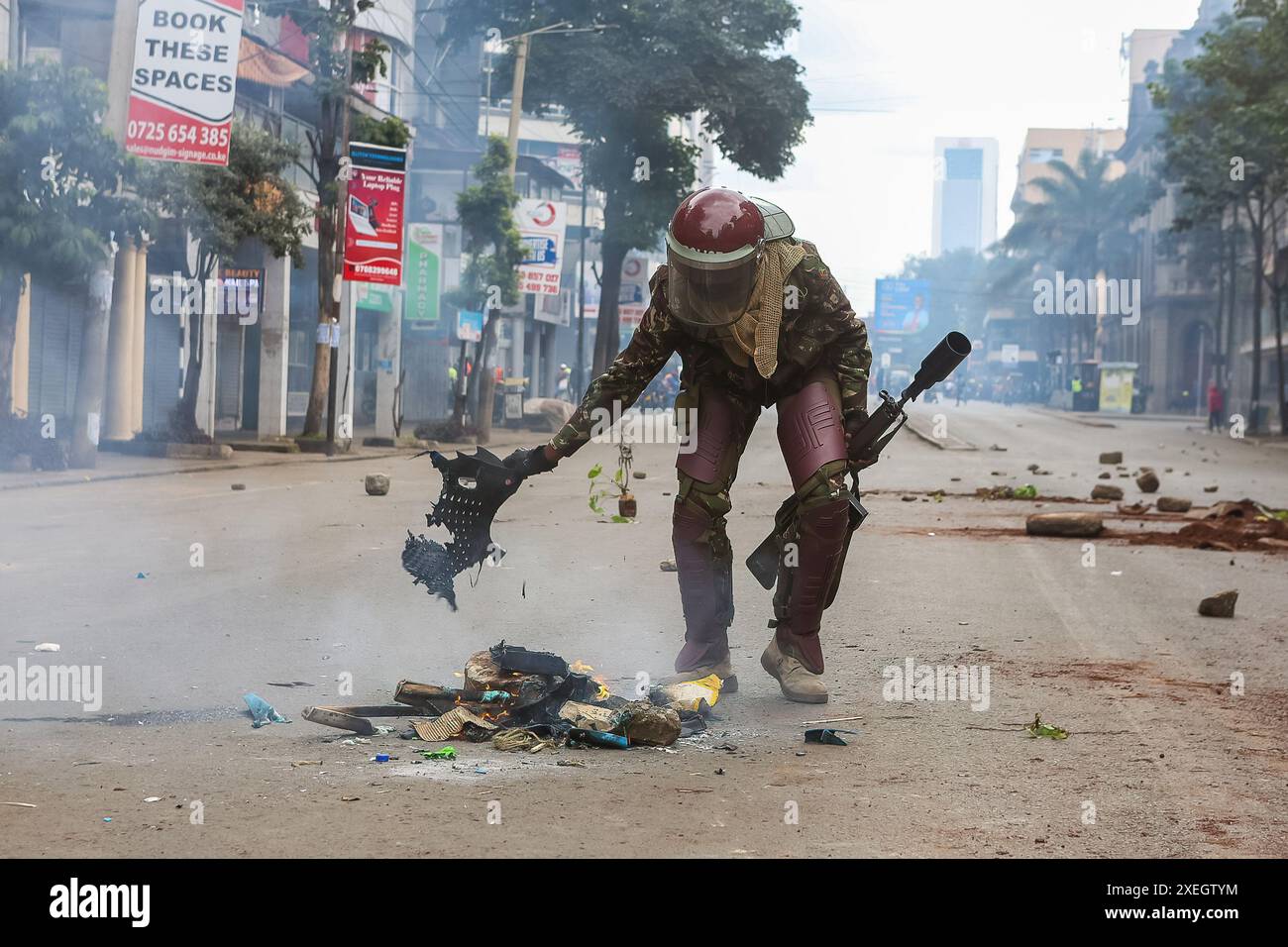 Nairobi, Kenya. 27th June, 2024. Anti-riot police puts off a fire lit ...