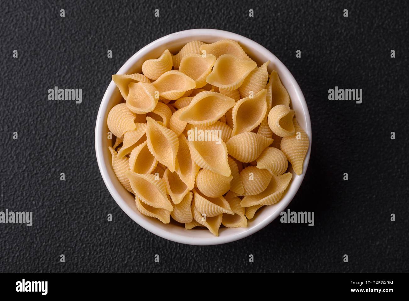 Raw Italian pasta conchiglie from durum wheat with vegetables, salt and ...