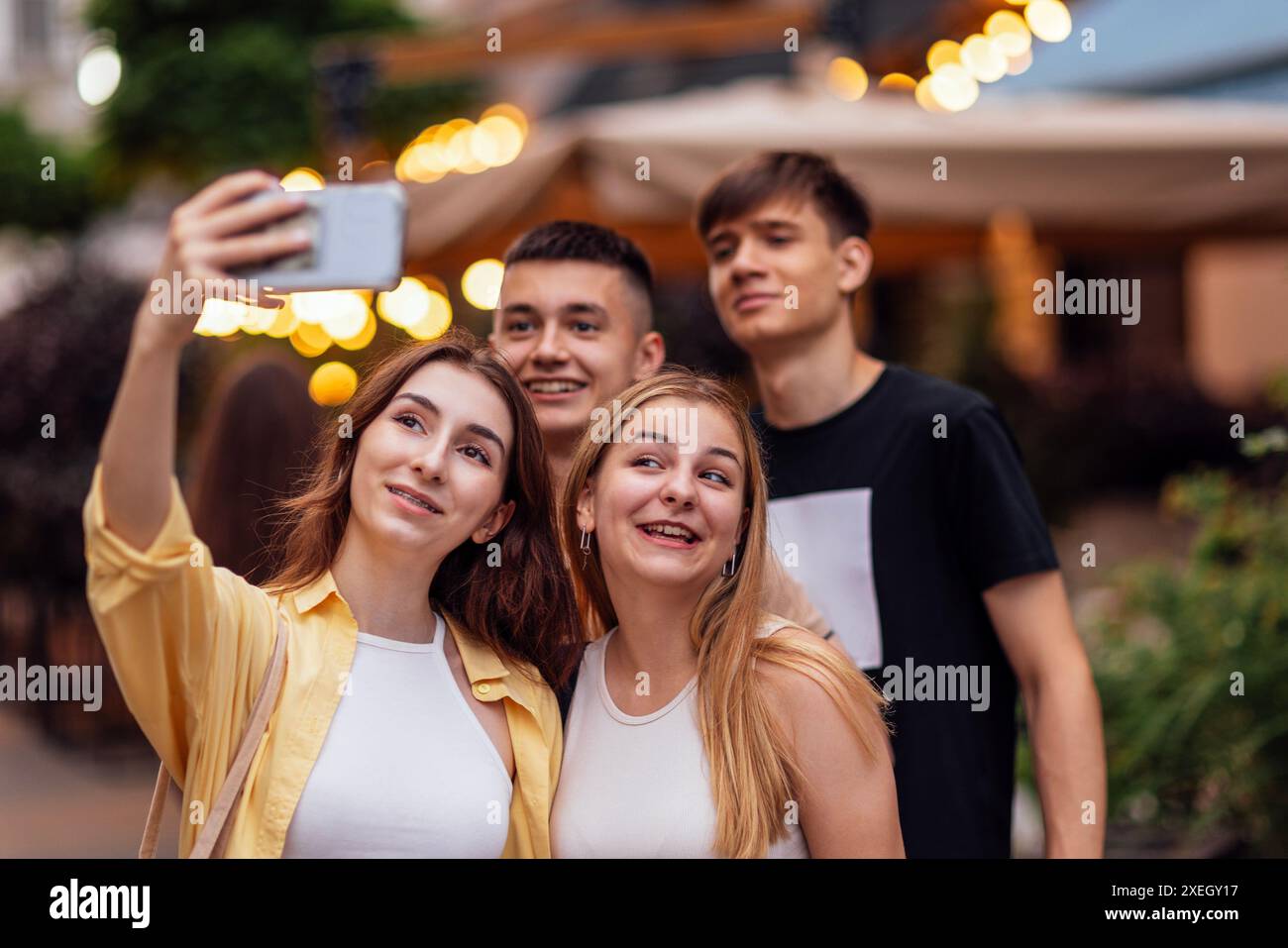 Four cute teenagers taking a selfie. Funny friends takes a picture of ...