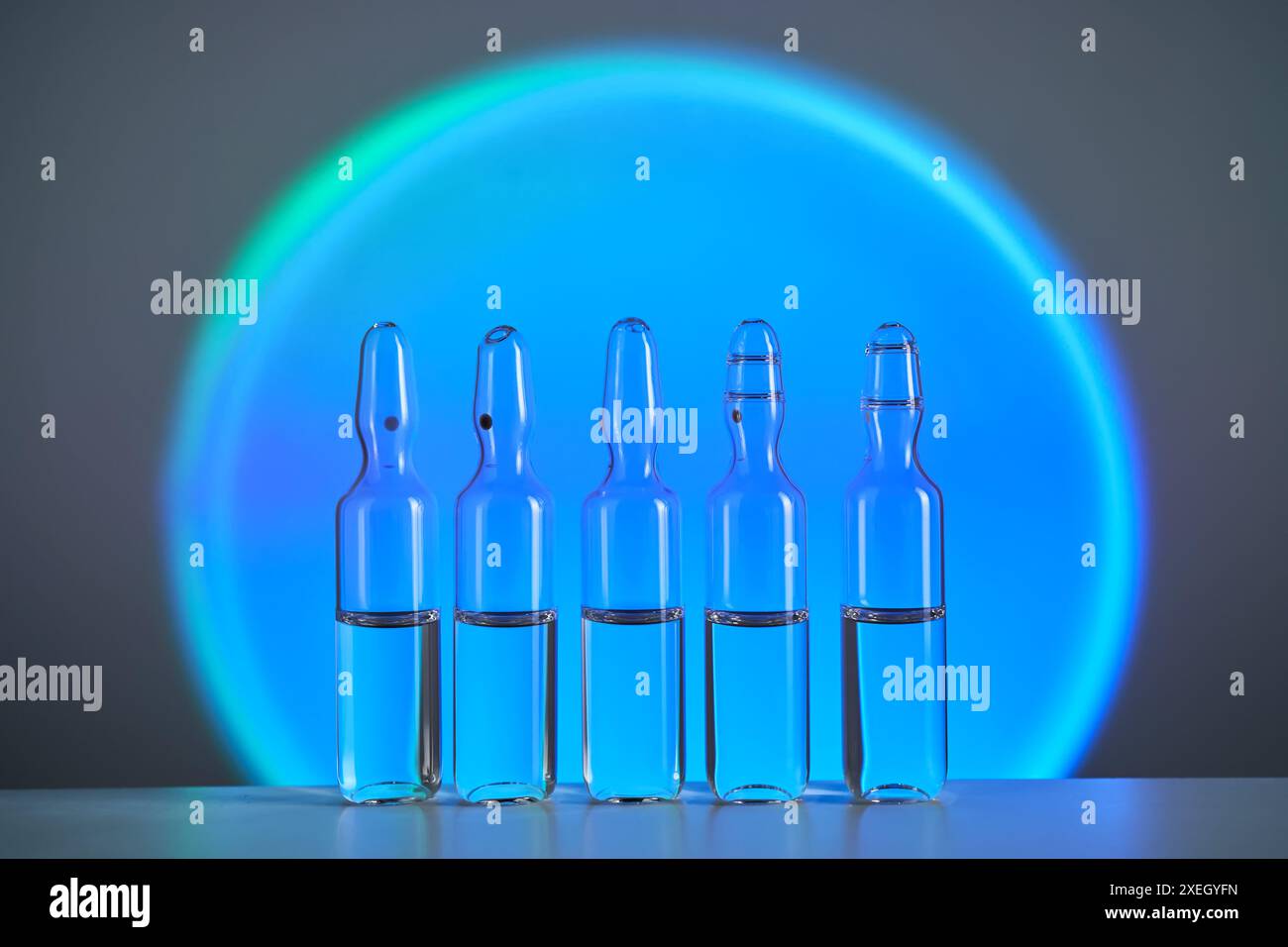 Several ampoules for injection with medicines on a blue background ...