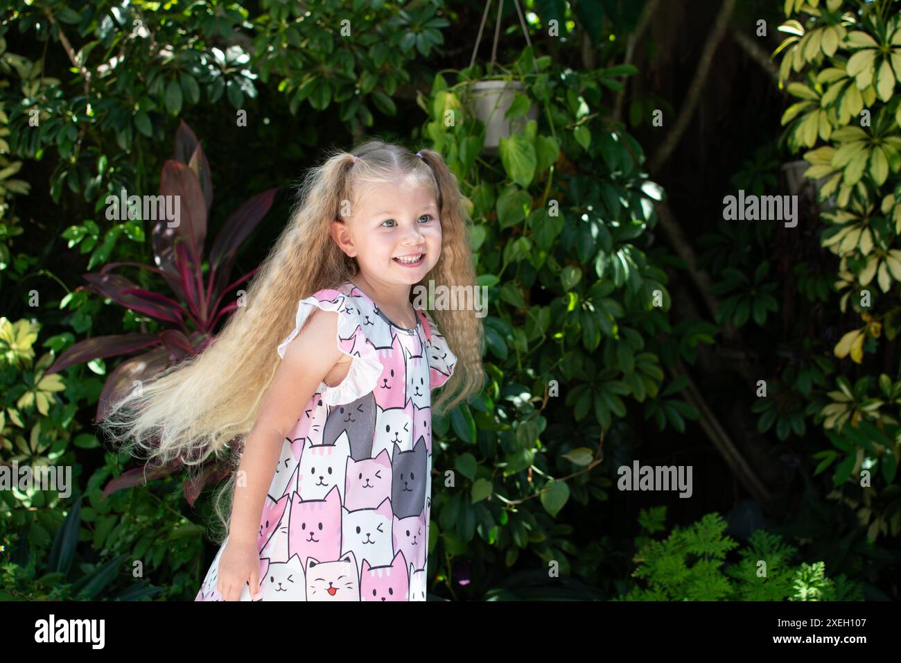 Happy kid playing in summer park. Little girl dancing in beautiful ...