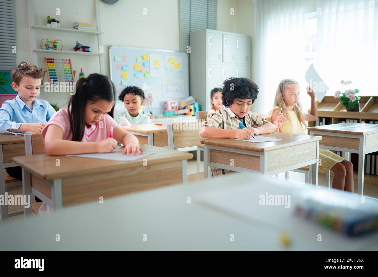 Students learn and study in a classroom of school where youngsters sit ...