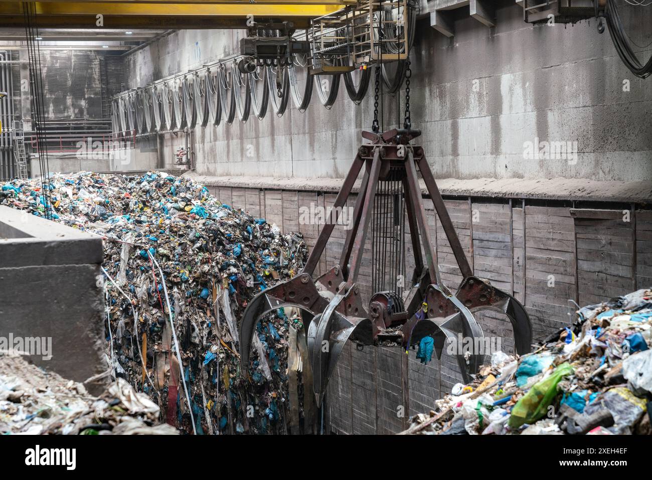 Grab crane picks up the waste for incineration in a waste-to-energy ...