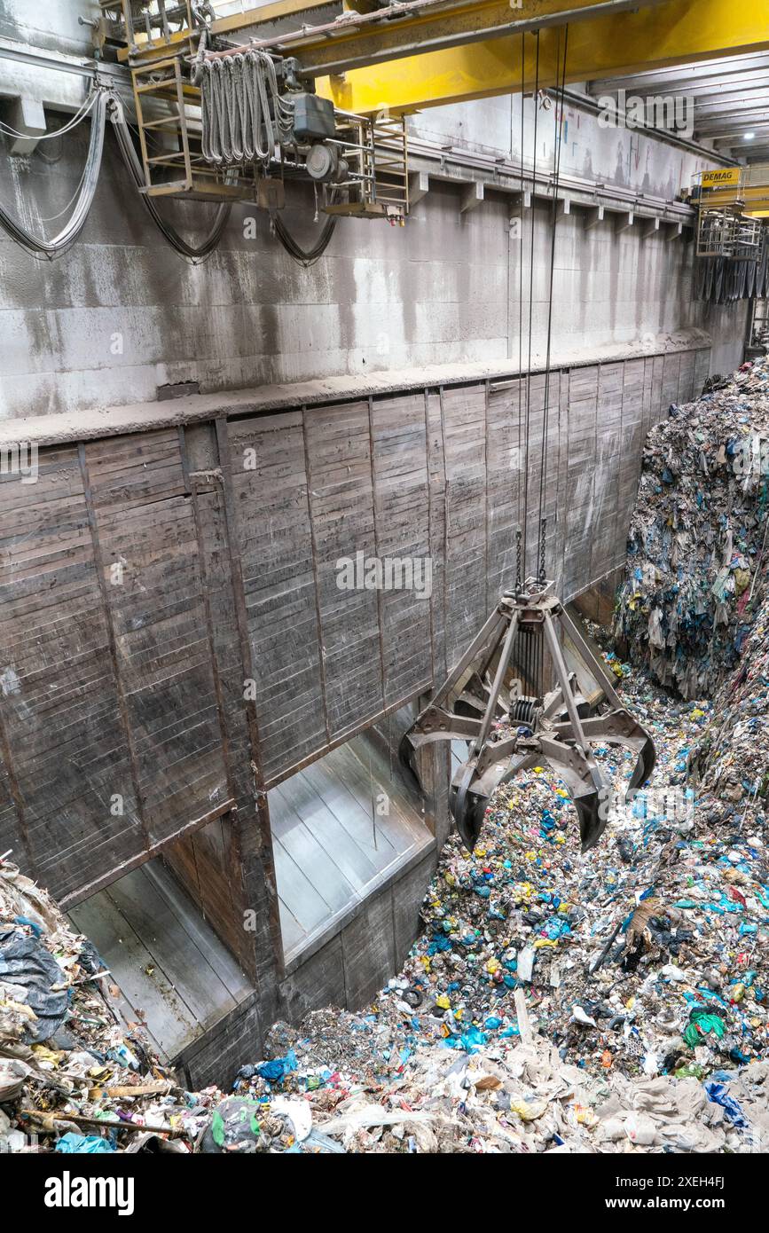 Grab crane picks up the waste for incineration in a waste-to-energy ...