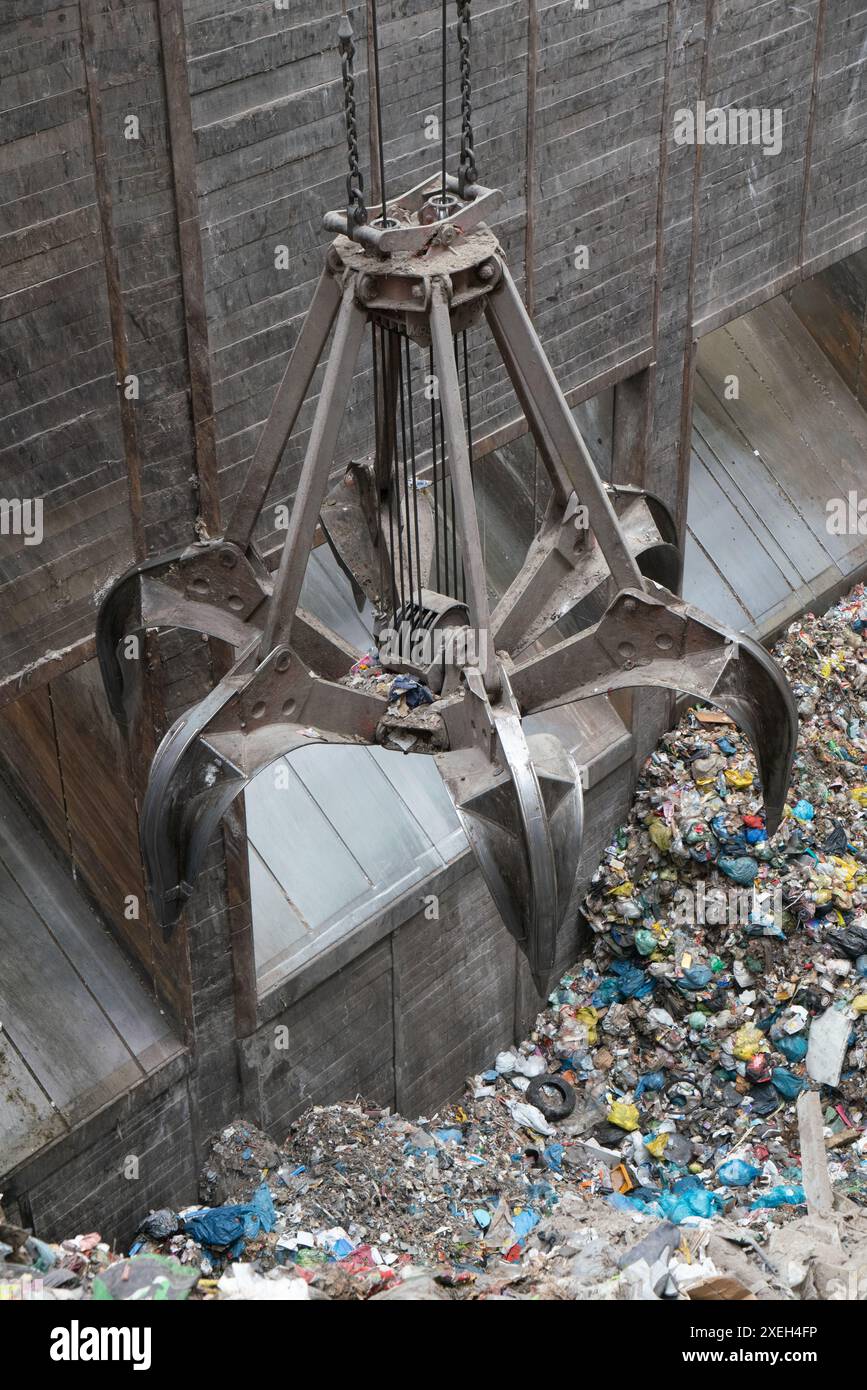 Grab crane picks up the waste for incineration in a waste-to-energy ...