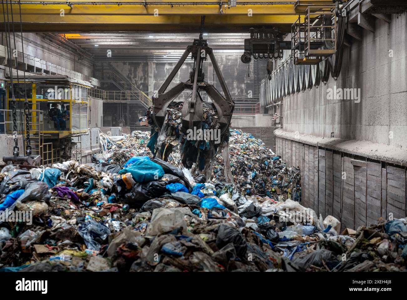 Grab crane picks up the waste for incineration in a waste-to-energy ...