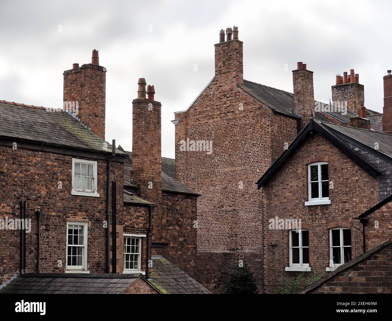 A group of old british brick houses with slate roofs and tall chimneys ...