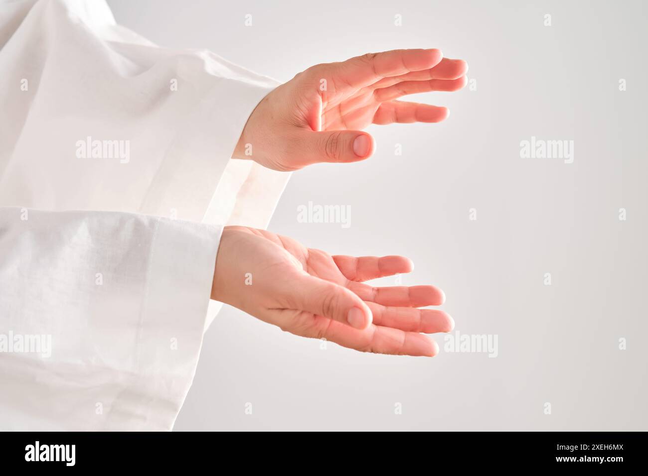 Female hands in a white robe stretch to the right Stock Photo - Alamy
