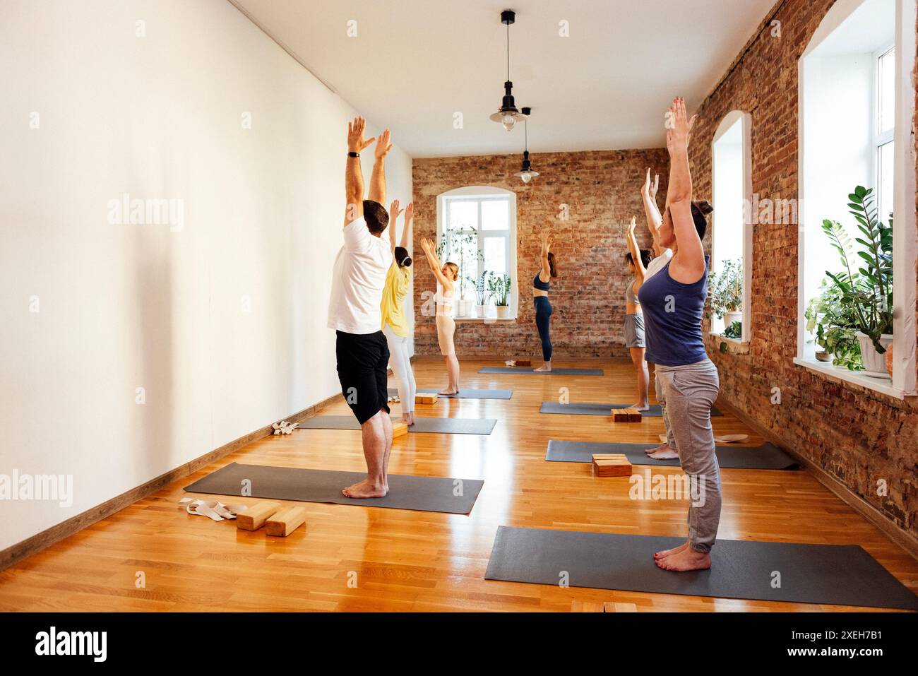 Multiracial smiling people practicing yoga asanas with instructor ...