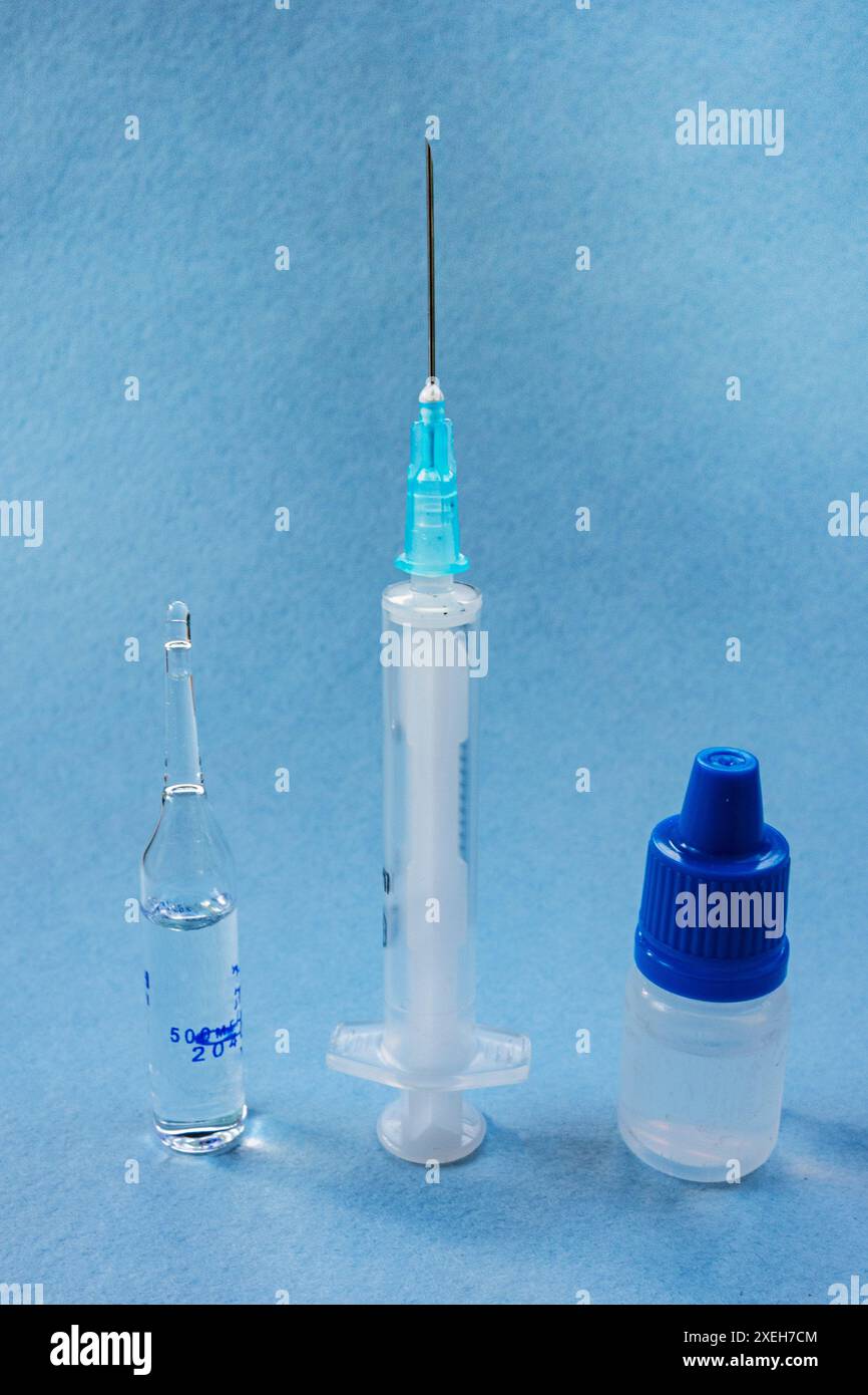 Two different syringes for injections and a plastic bottle with ...