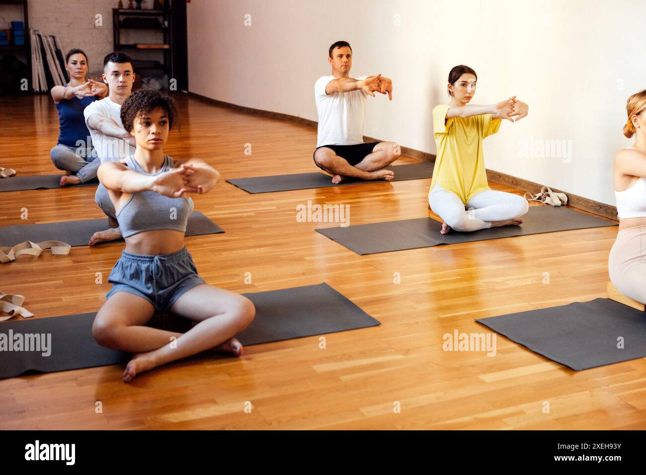 Athletic people of different ages and races practice yoga asanas with ...