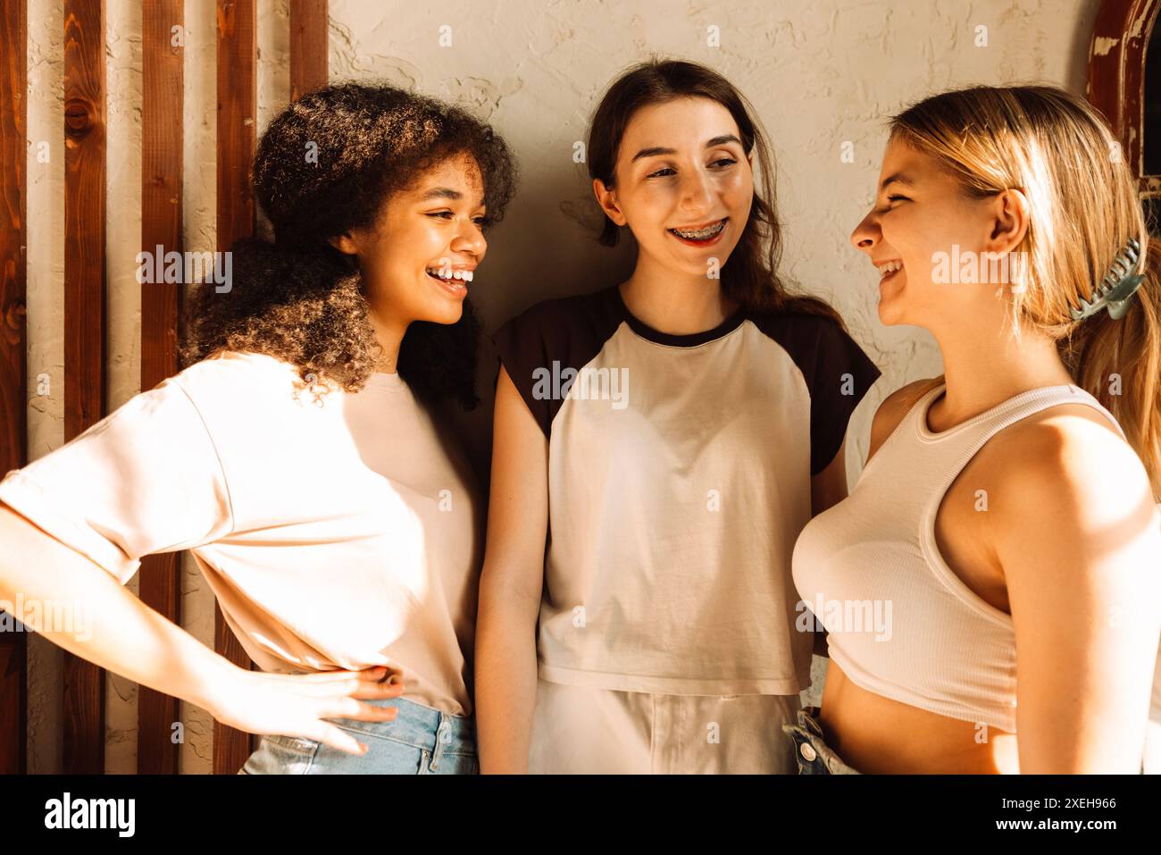 Happy cute girls of different races are laughing and chatting. Charming ...