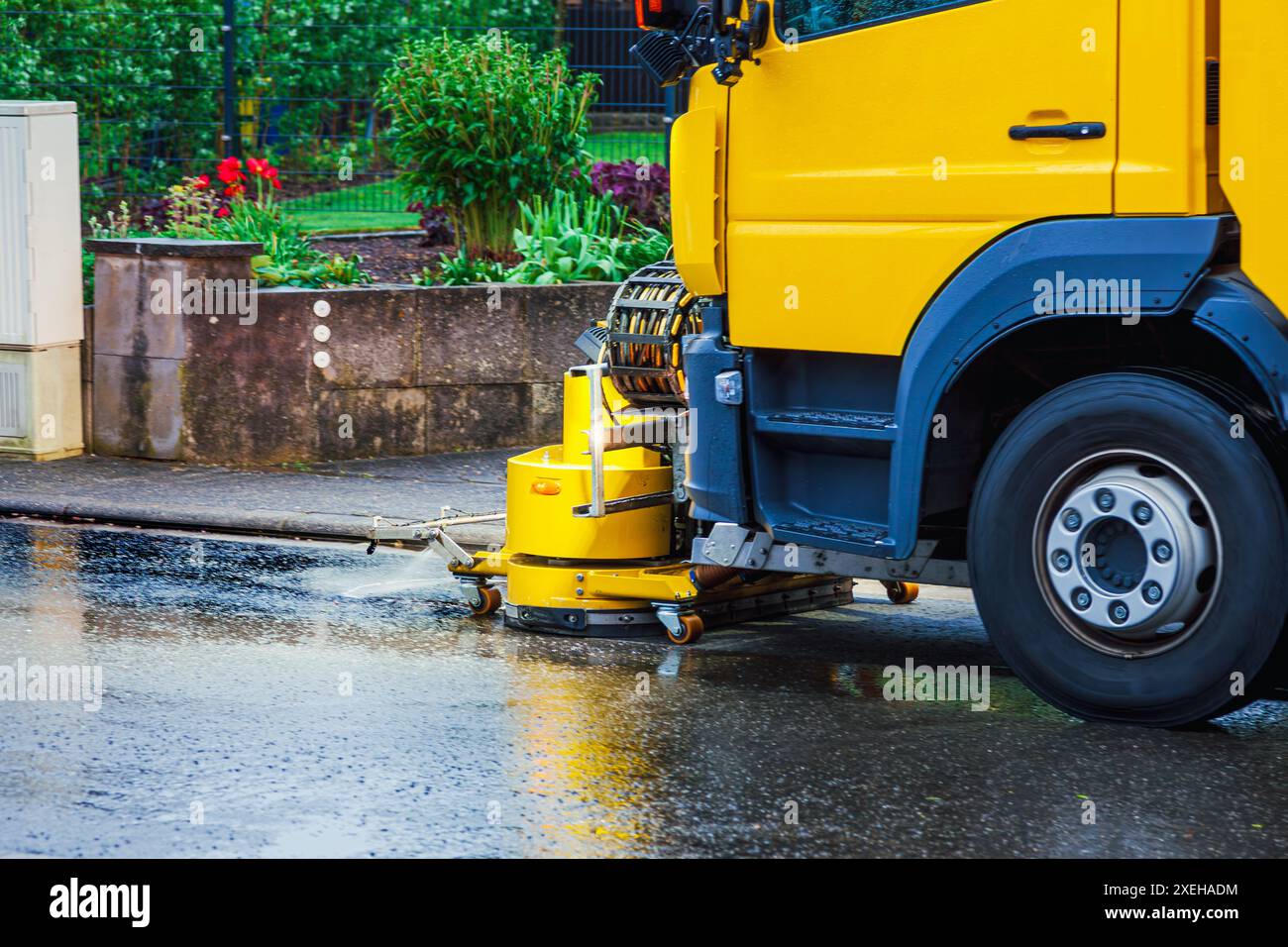 Removing oil spills. Yellow Truck remove engine oil from a street. oil ...