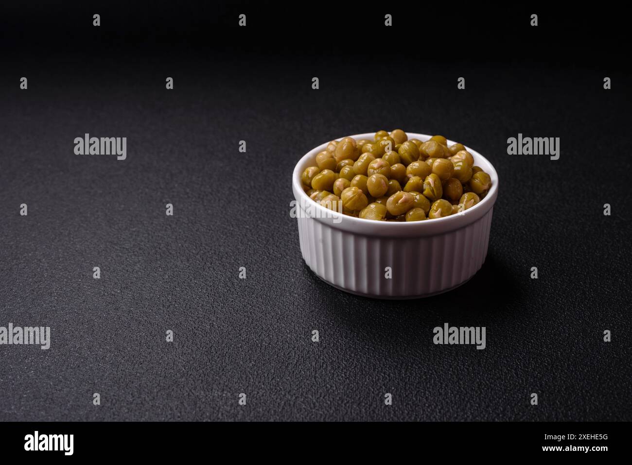 Delicious canned green peas with salt and spices in a white bowl Stock ...