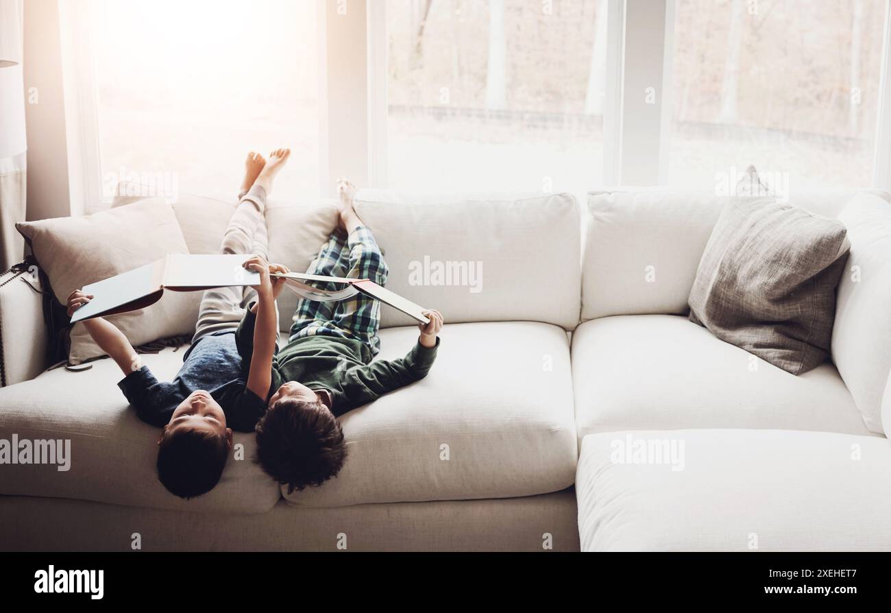 Upside down, reading books and boys on couch, hobby and activity with ...
