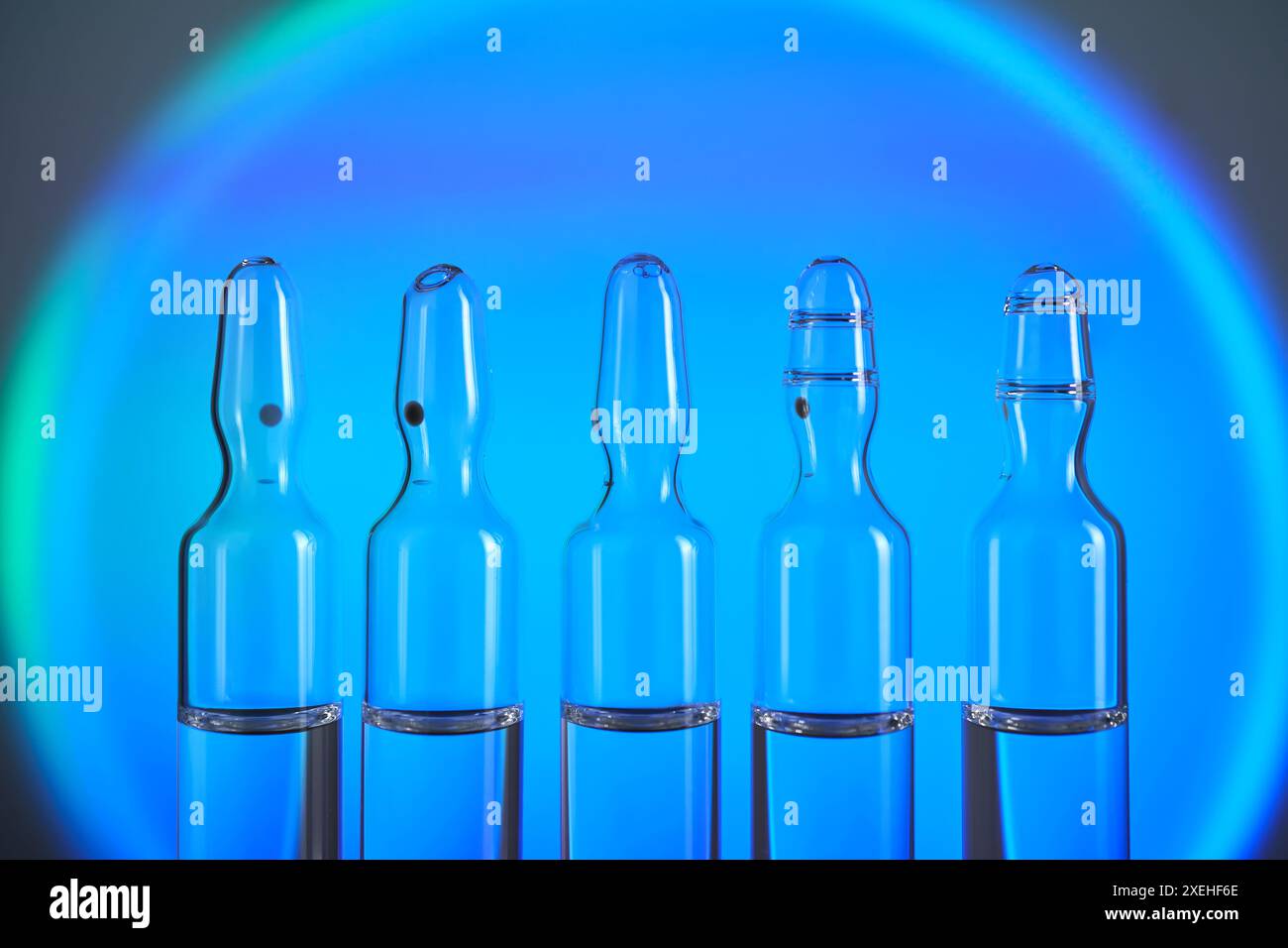 Several ampoules for injection with medicines on a blue background ...