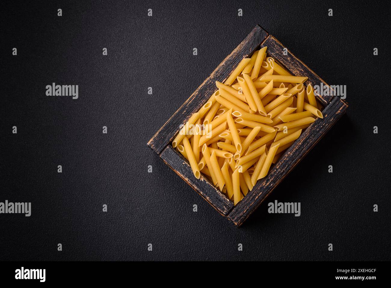 Raw penne pasta from whole grain wheat varieties with salt and spices ...