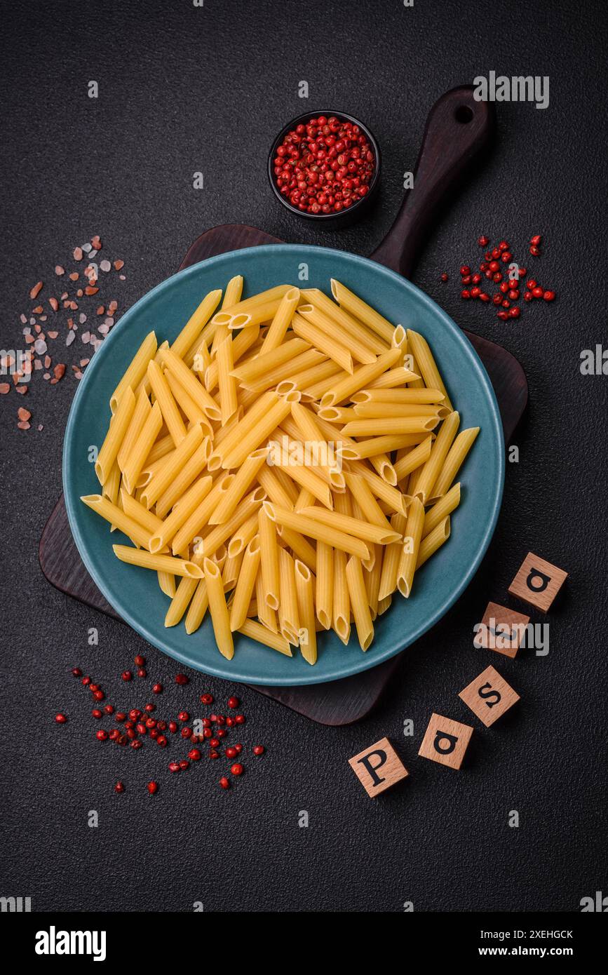 Raw penne pasta from whole grain wheat varieties with salt and spices ...