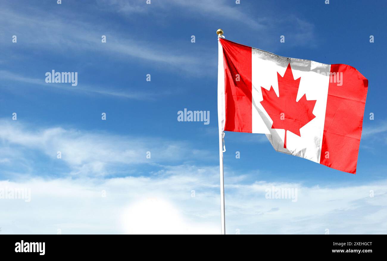 Canadian flag on cloudy sky. flying in the sky Stock Photo - Alamy