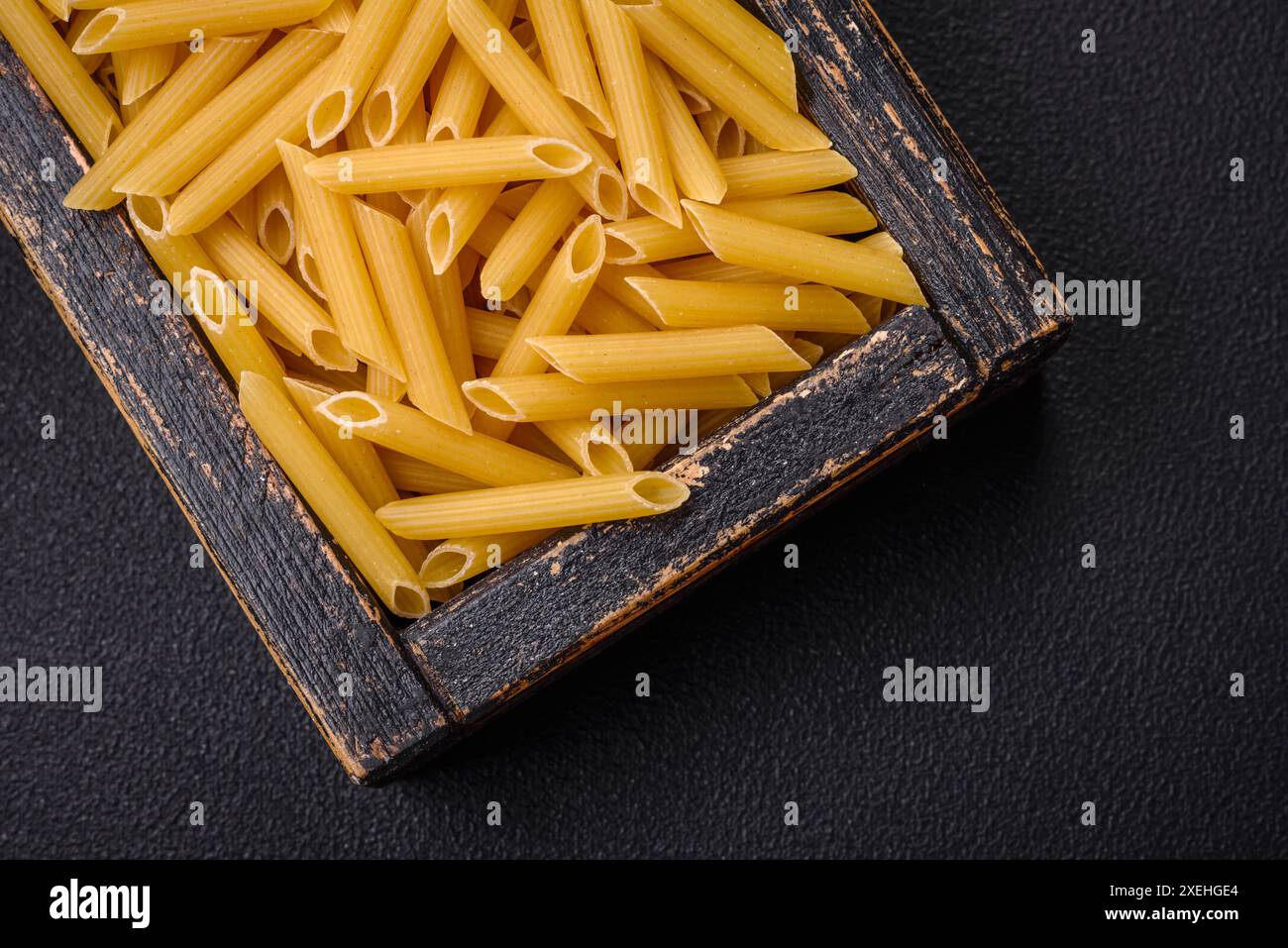 Raw penne pasta from whole grain wheat varieties with salt and spices ...