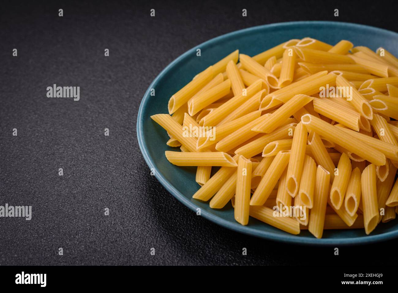 Raw penne pasta from whole grain wheat varieties with salt and spices ...