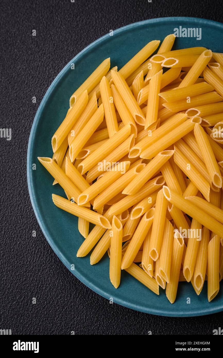 Raw penne pasta from whole grain wheat varieties with salt and spices ...