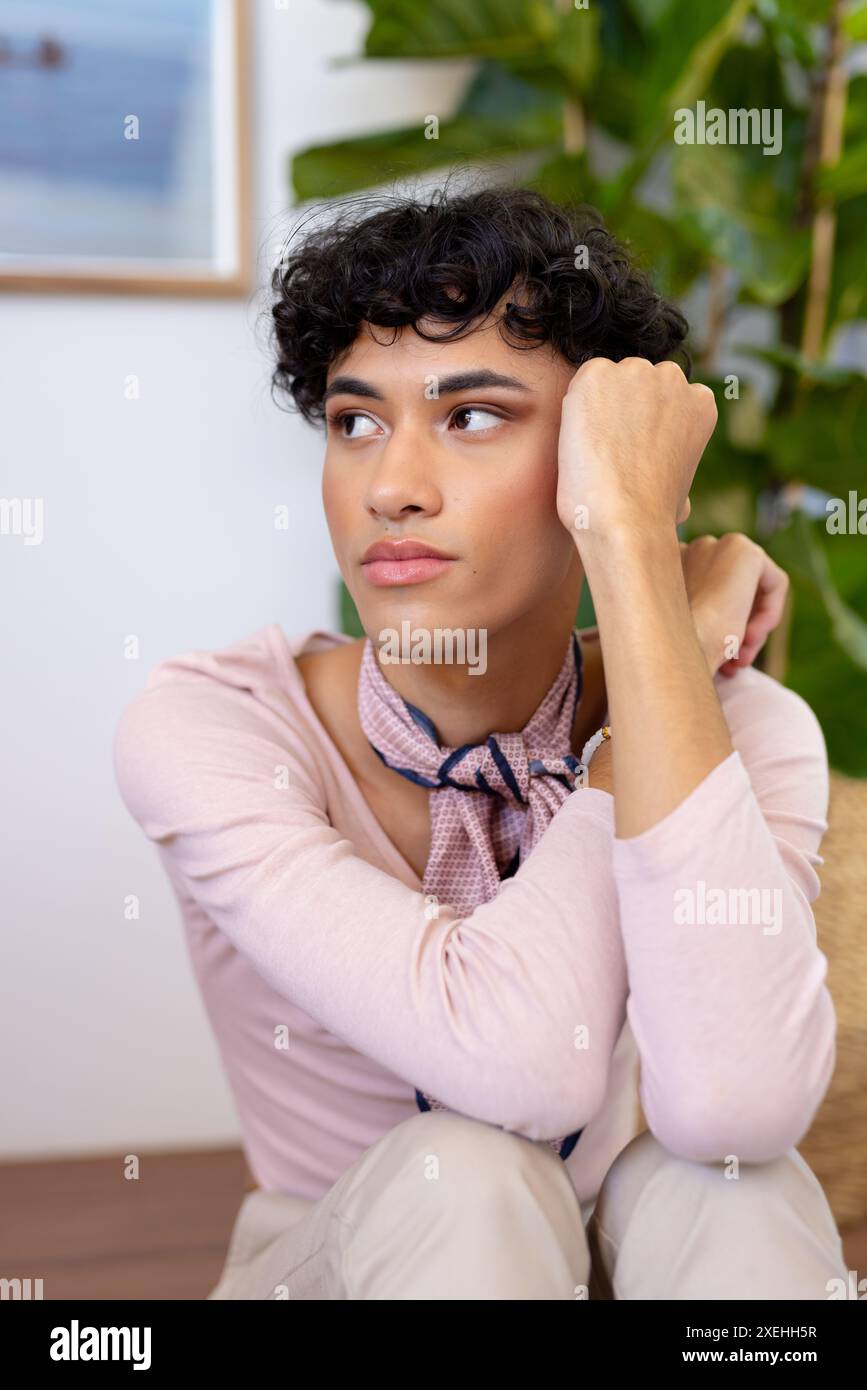 Sitting indoors, thoughtful transgender transgender woman resting chin ...