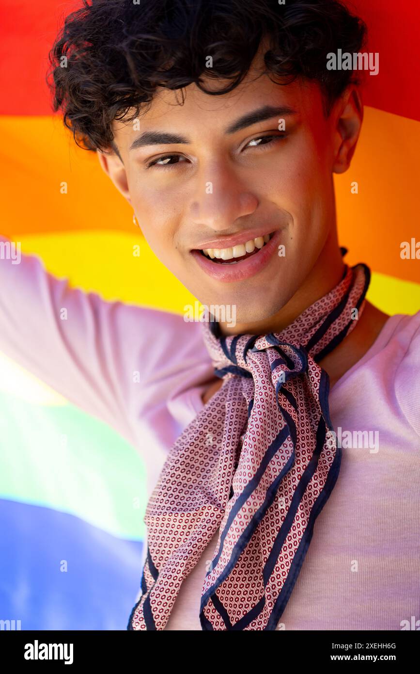 Smiling young man holding rainbow flag, celebrating LGBTQ+ pride and ...