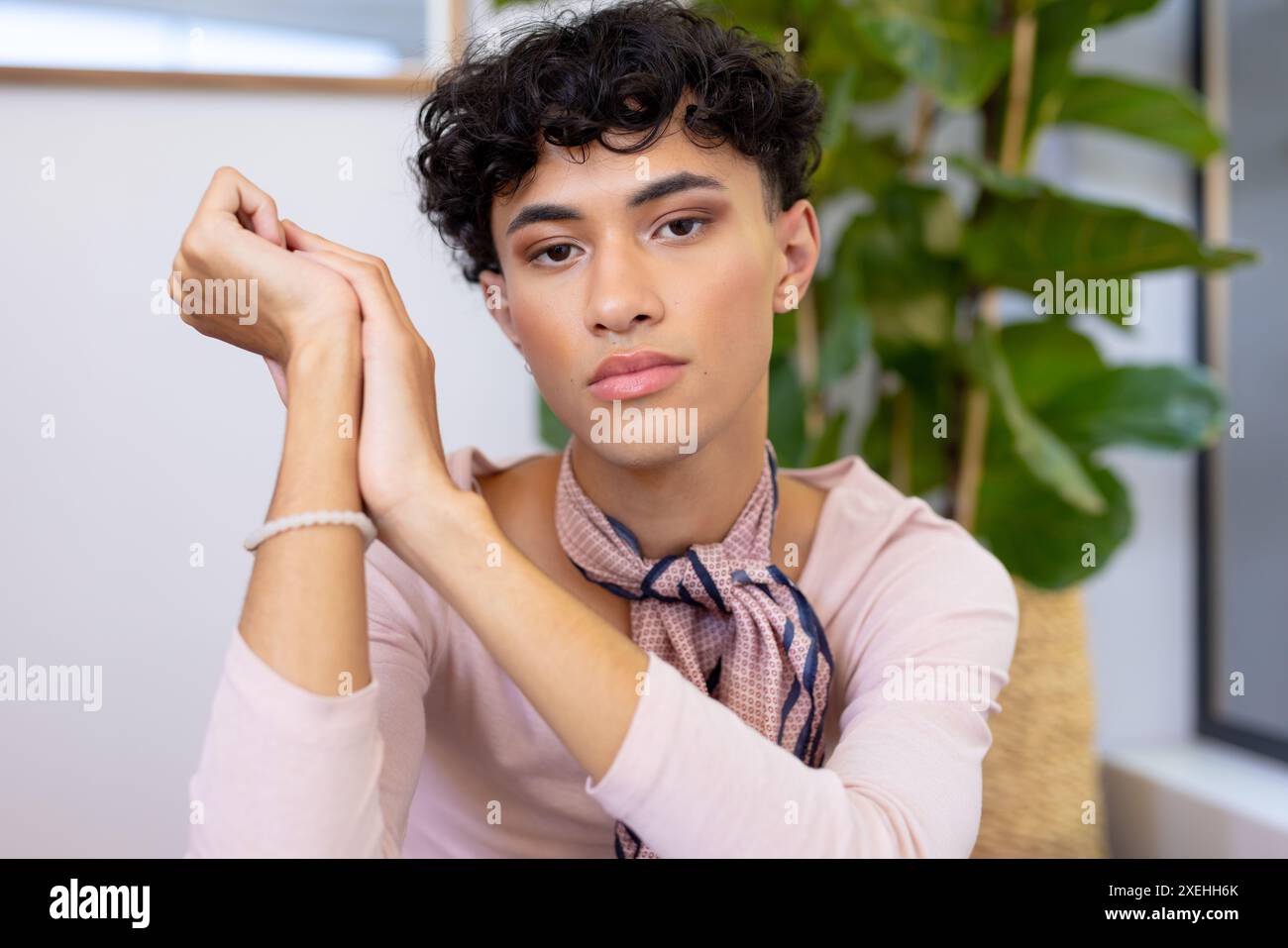 Posing indoors, transgender transgender woman sitting with thoughtful ...