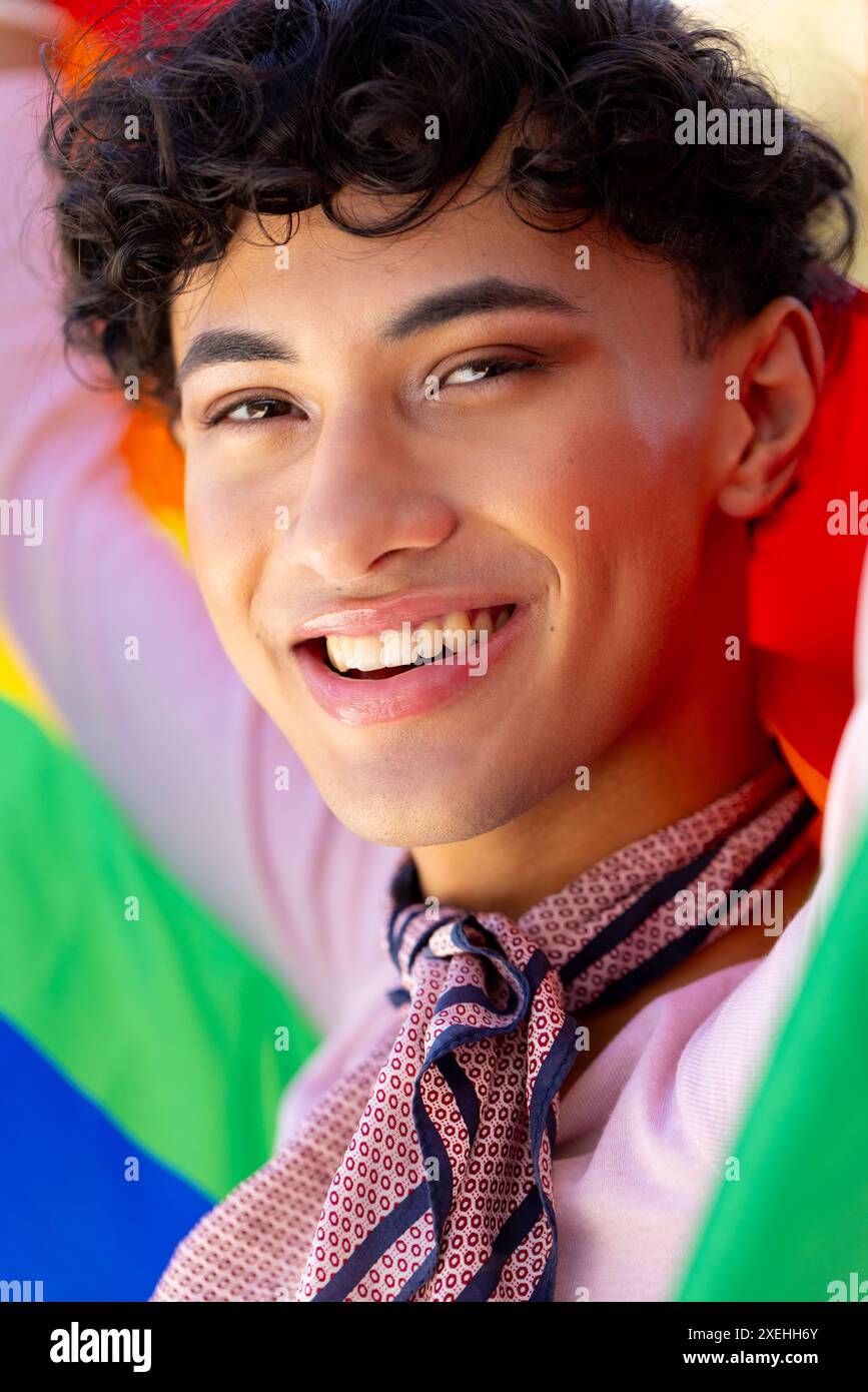 Celebrating LGBTQ+ pride, smiling transgender woman holding rainbow ...