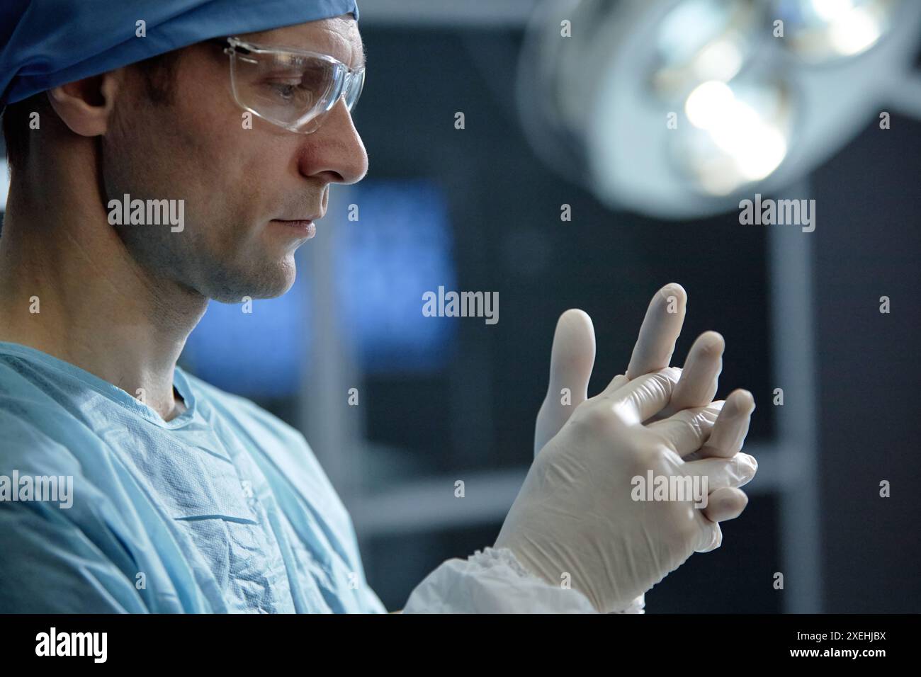 Side view portrait of focused male surgeon adjusting protective ...
