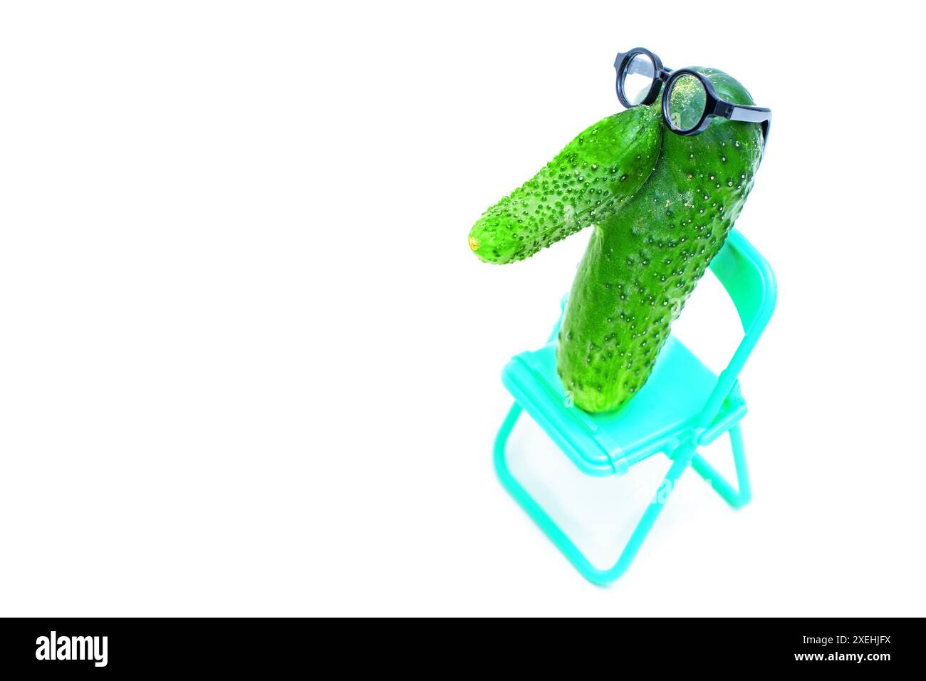 Nosy cucumber character in stylish eyeglasses sits on a folding chair ...