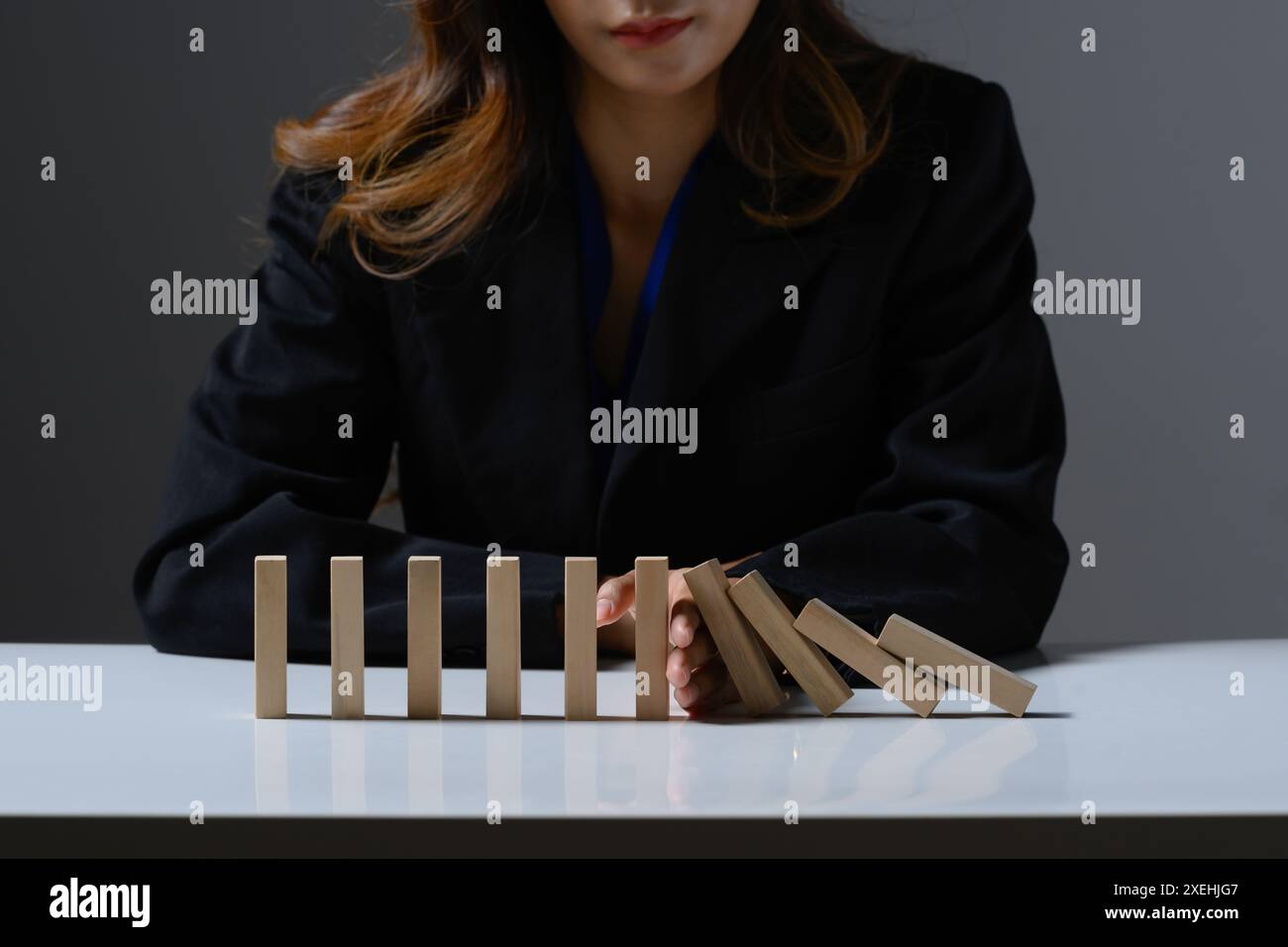 Businessperson hand stopping falling wooden blocks. Financial risk ...