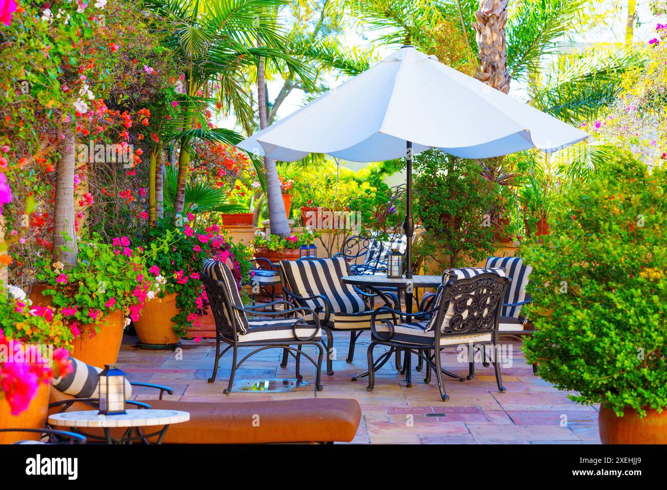 Serene outdoor dining area featuring a table and chairs under a white ...