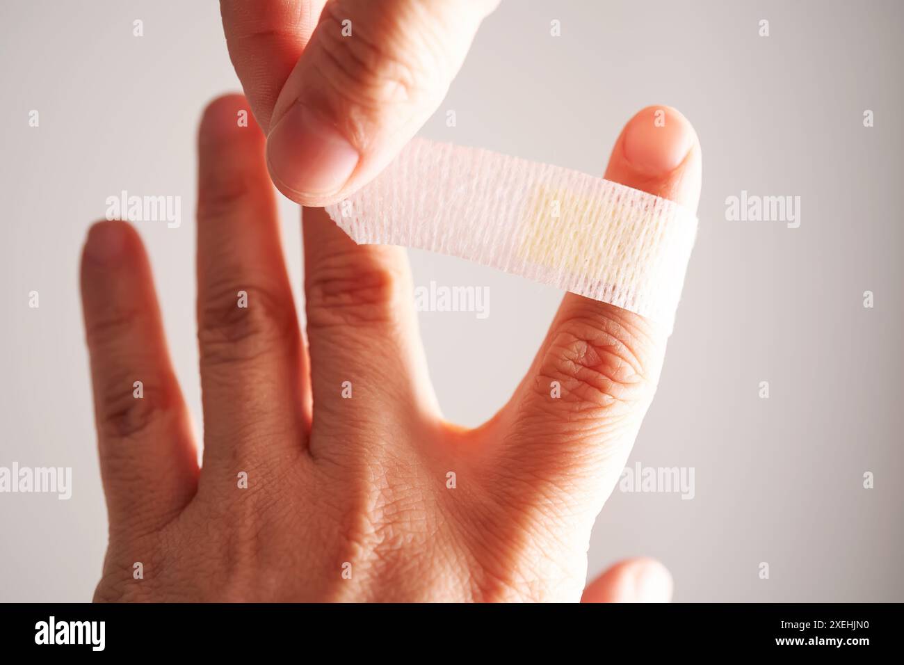 Applying an adhesive plaster to a finger. Close-up Stock Photo - Alamy