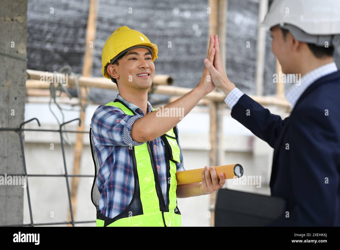 Team of architects or structural engineers giving high five and ...