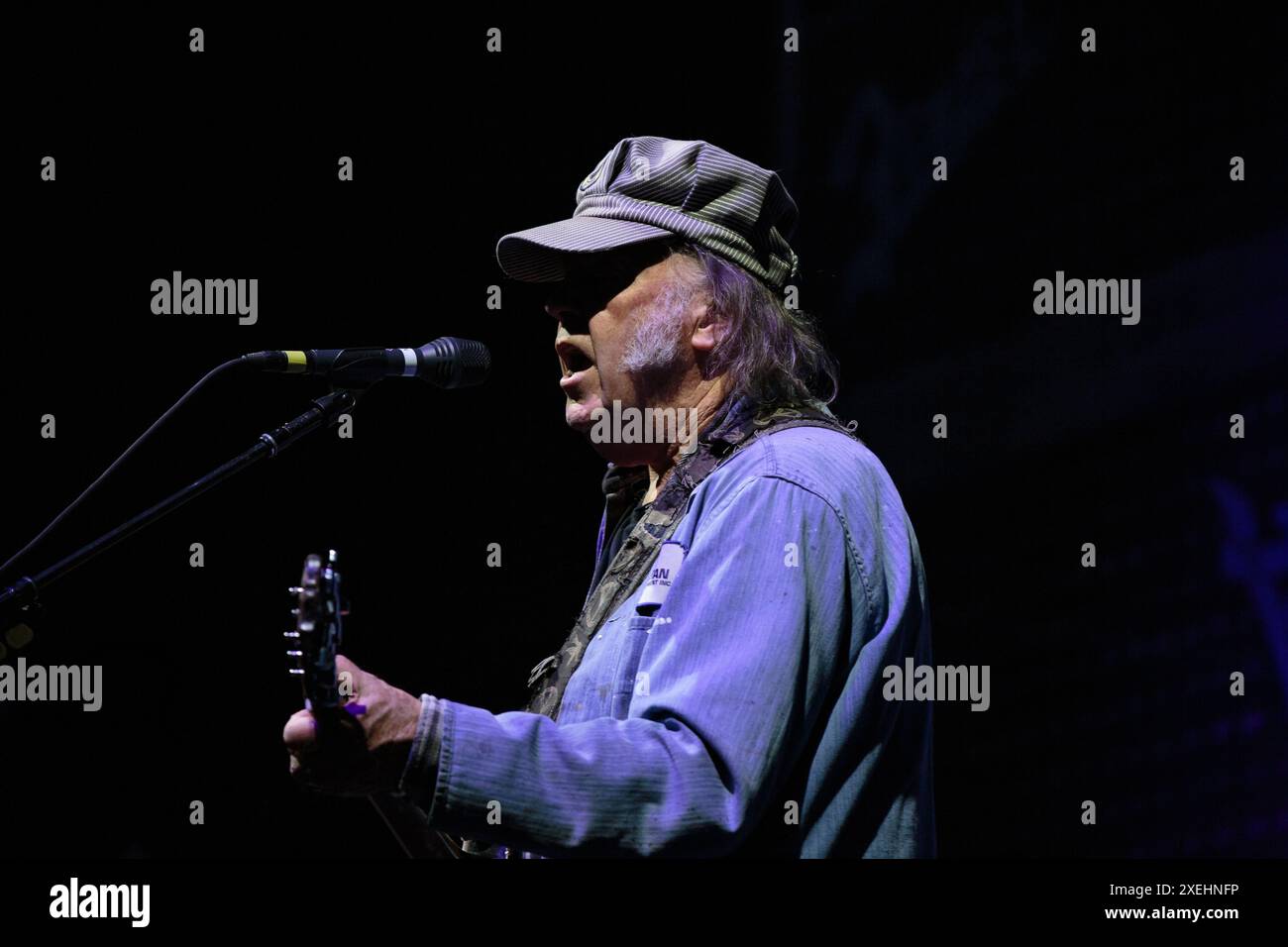Neil Young on stage singing and playing guitar Stock Photo - Alamy